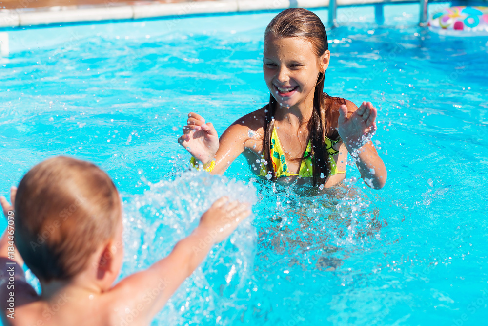 Little children playing and having fun in swimming pool with air ...