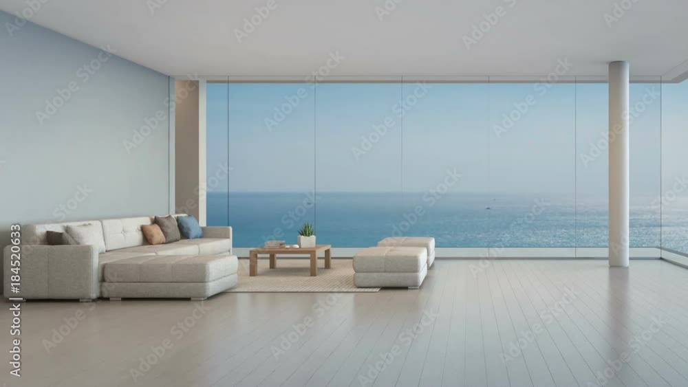 Large sofa on wooden floor near glass window with ocean and sky ...