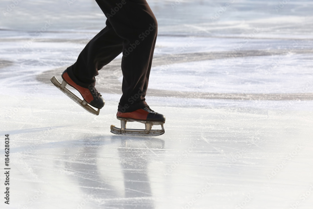 feet on the skates of a person rolling on the ice rink. Stock Photo ...