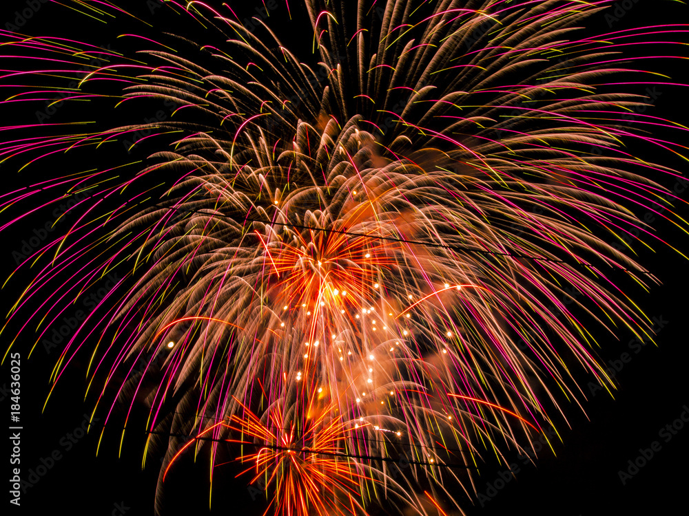 vertical fireworks explode and fill the dark night sky with numerous ...