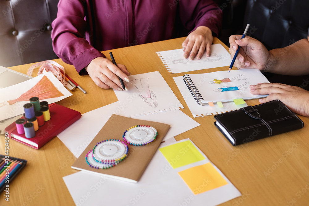 Two young professional Fashion designer colleagues working and project ...