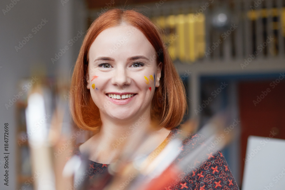 Close up portrait of redheaded female painter captured in time of ...