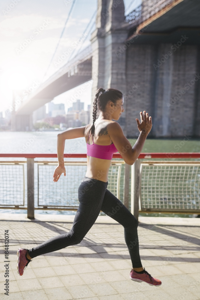 Woman doing stretching exercises in Manhattan near Brooklyn Bridge in ...