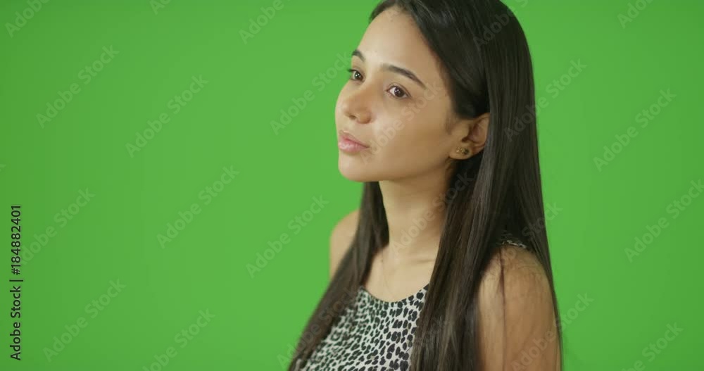A young girl poses for a portrait on green screen. On green screen to ...