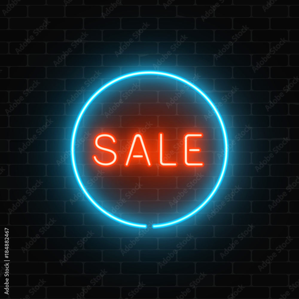 Neon red sale sign in a blue circle frame on a dark brick wall ...