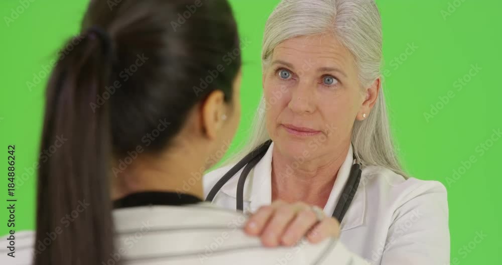 A doctor gives medical information to her patient on green screen. On ...