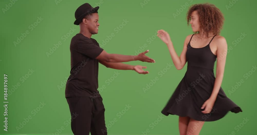 Black couple dances on green screen. On green screen to be keyed or ...