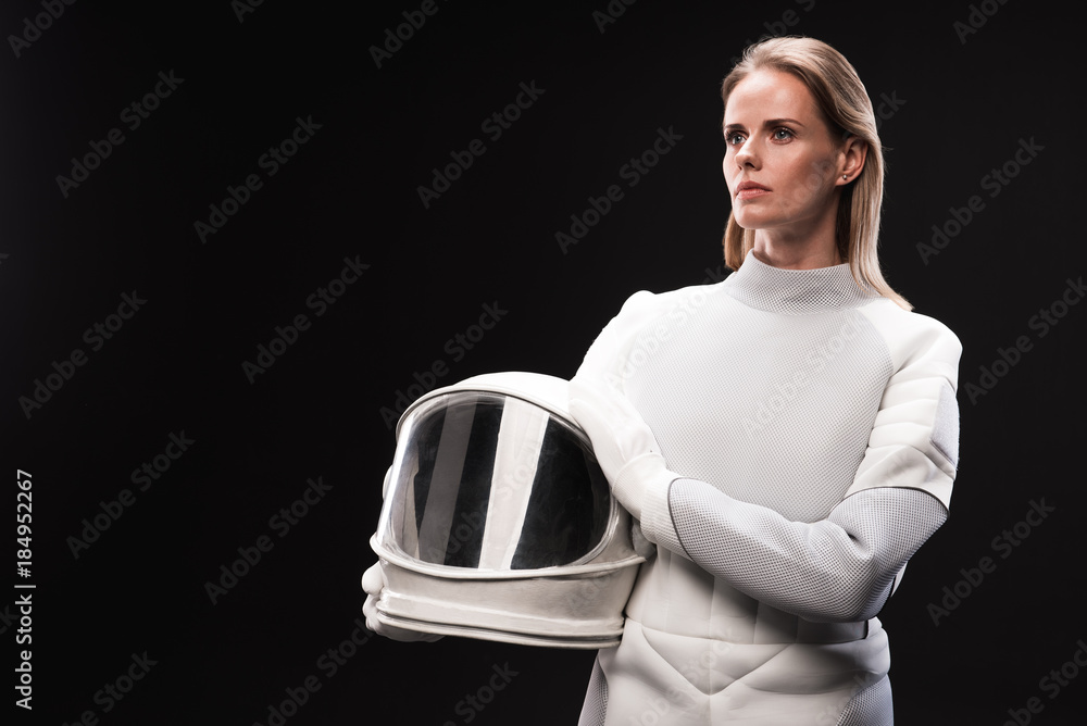 Young lady astronaut wearing protective costume is standing and looking ...