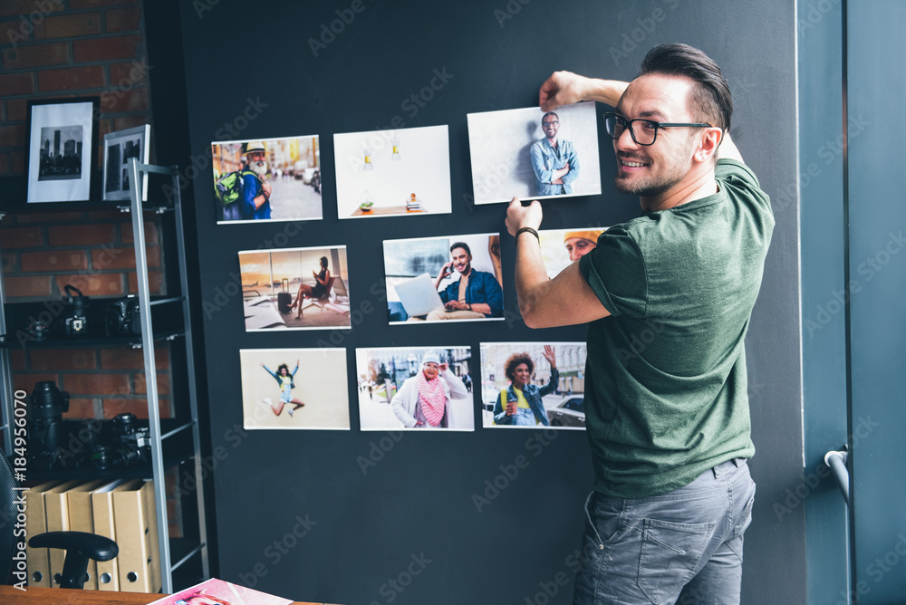 Side view smiling unshaven photographer applying depictions while ...