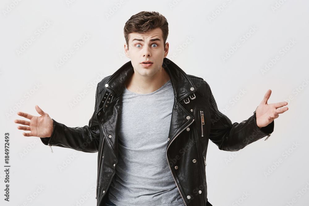 Shocked angry caucasian man in black leather jacket, looks with eyes ...