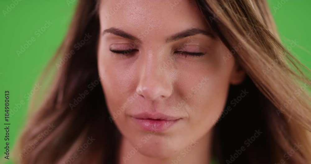 Close up of attractive millennial girl staring at camera on green ...