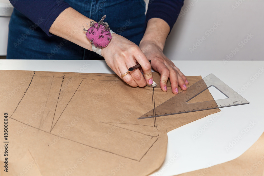 Seamstress is cutting drawing for a dress with scissors. Style and ...