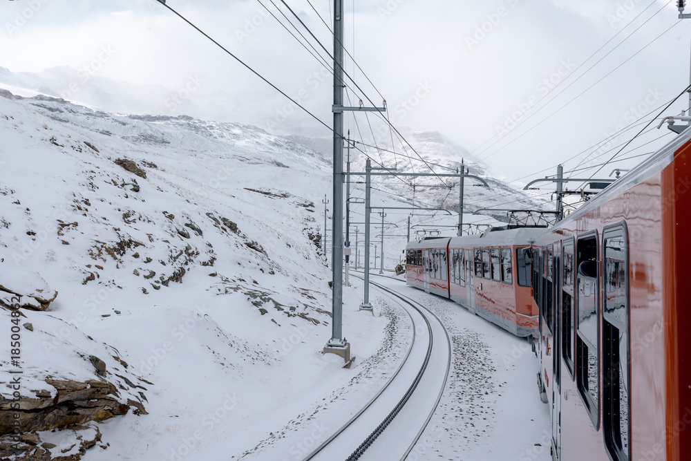 Red train of Gornergrat bahn with snow around Stock Photo | Adobe Stock