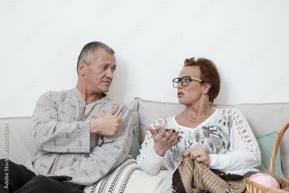 Casually dressed elderly Caucasian male and female relaxing in bed ...