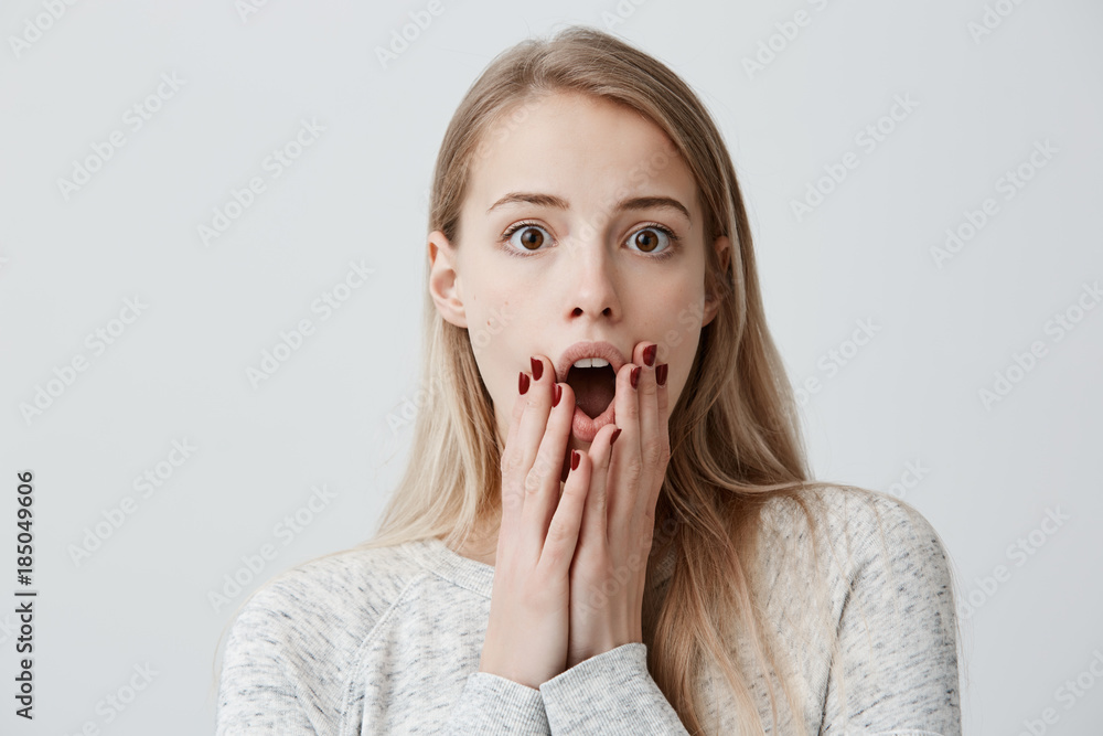 Young blonde woman with dark eyes dressed casually, staring with big ...