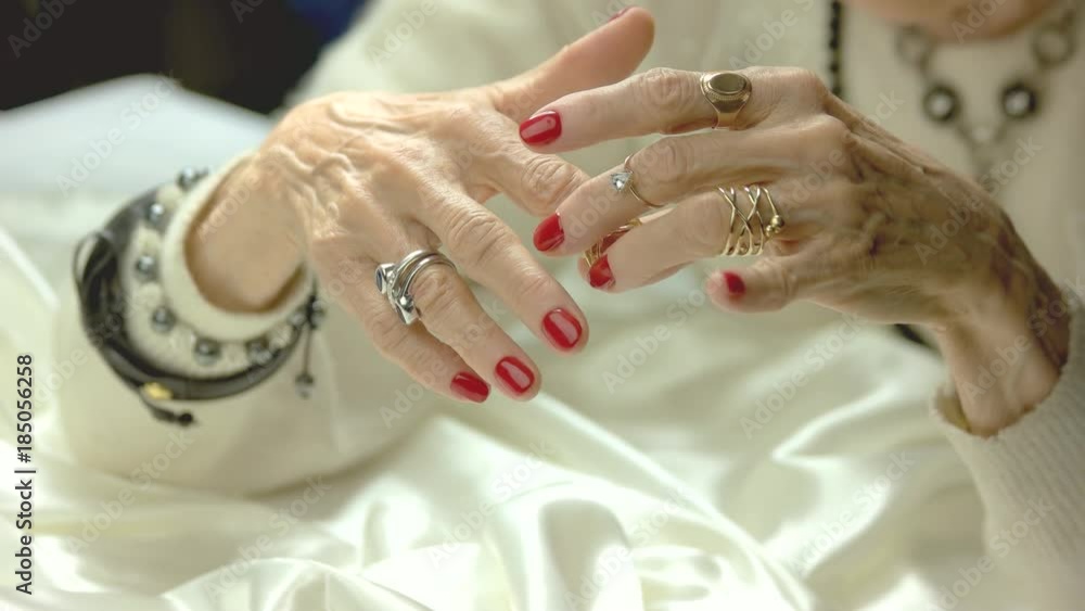Old woman putting on ring on finger. Elderly woman with well-groomed ...