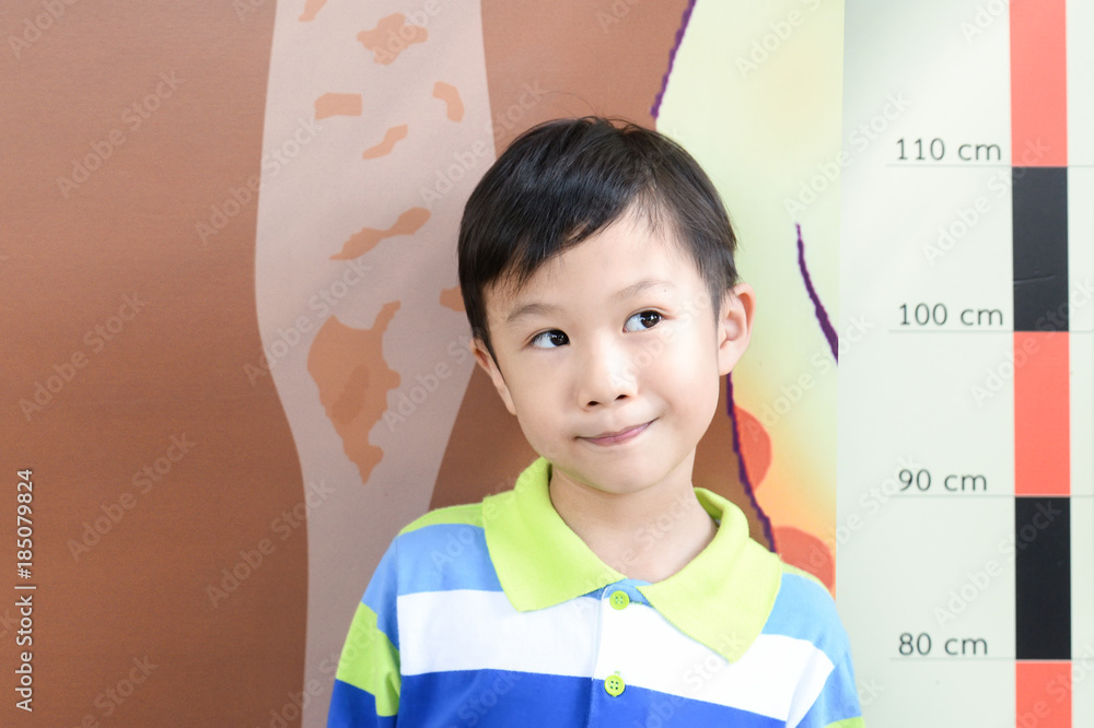 Little boy checking his height at school with measuring height scale on ...