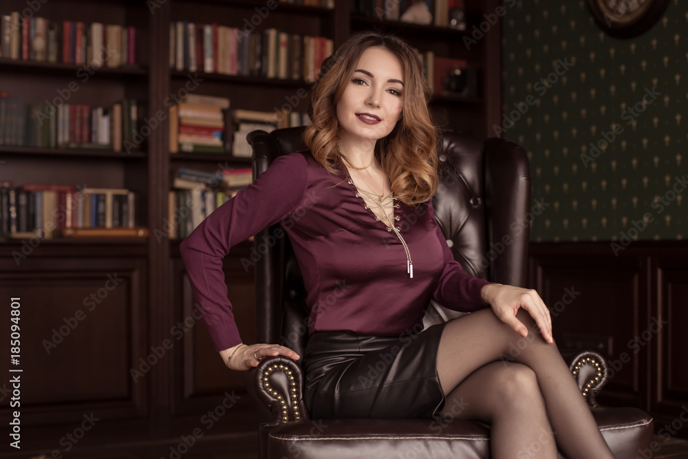 Beautiful woman sits in a brown leather chair, personal assistant ...
