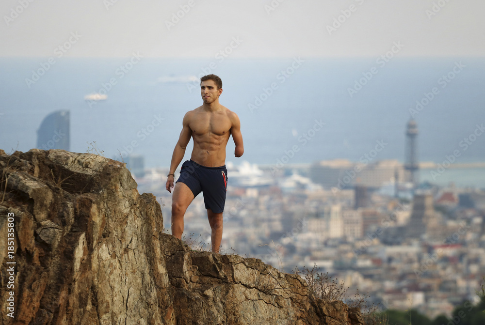 Physically challenged man standing on cliff against cityscape Stock ...