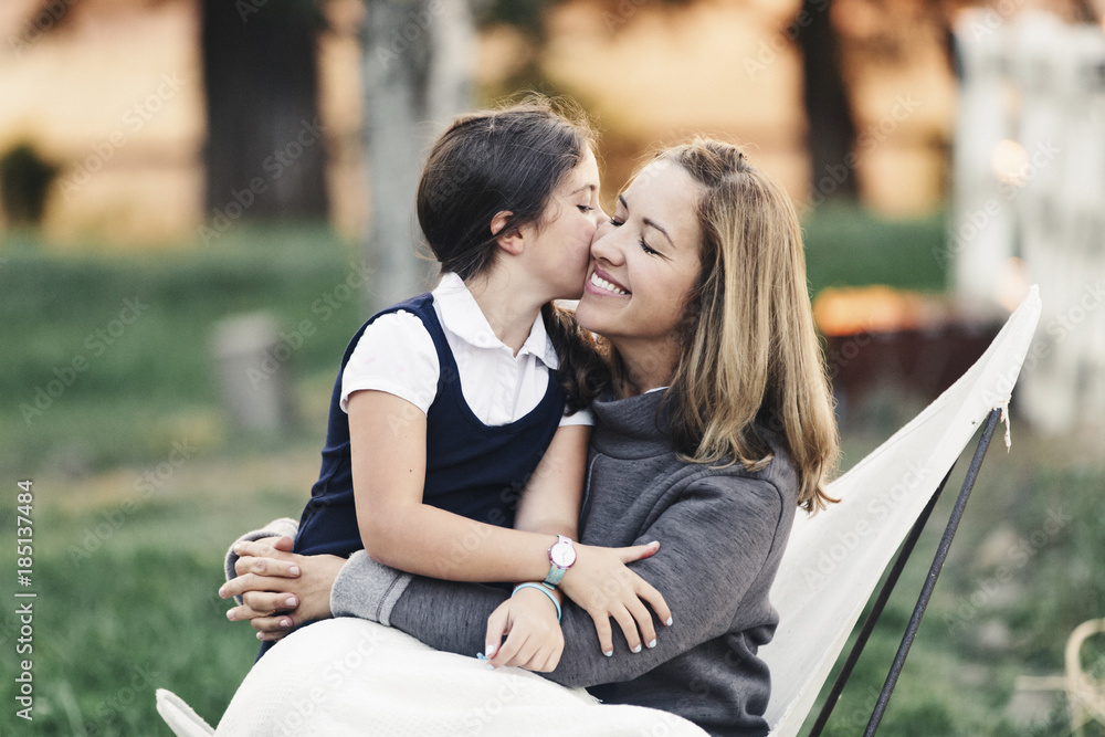Daughter wearing school uniform while kissing mother at yard Stock ...