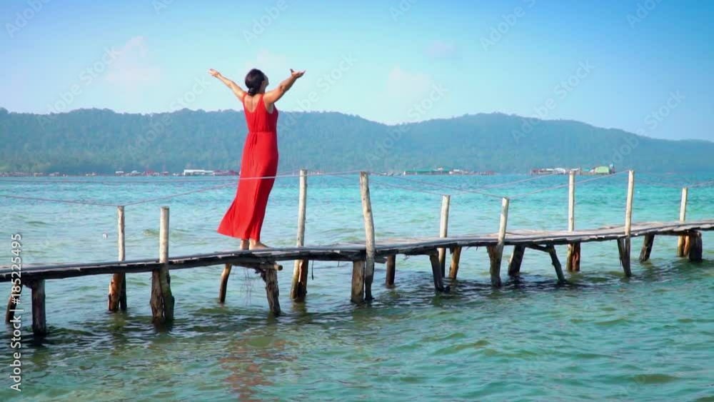 Video Stock Beautiful woman walking down pier in long red dress. Phu ...