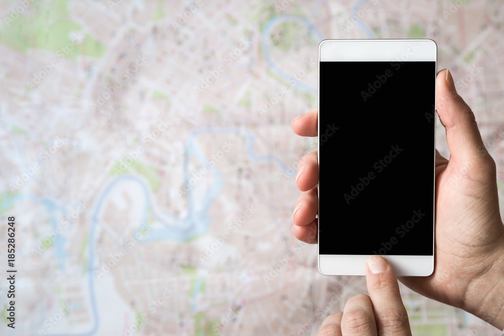 Hand holding and using a smart phone on the city map background. Empty ...