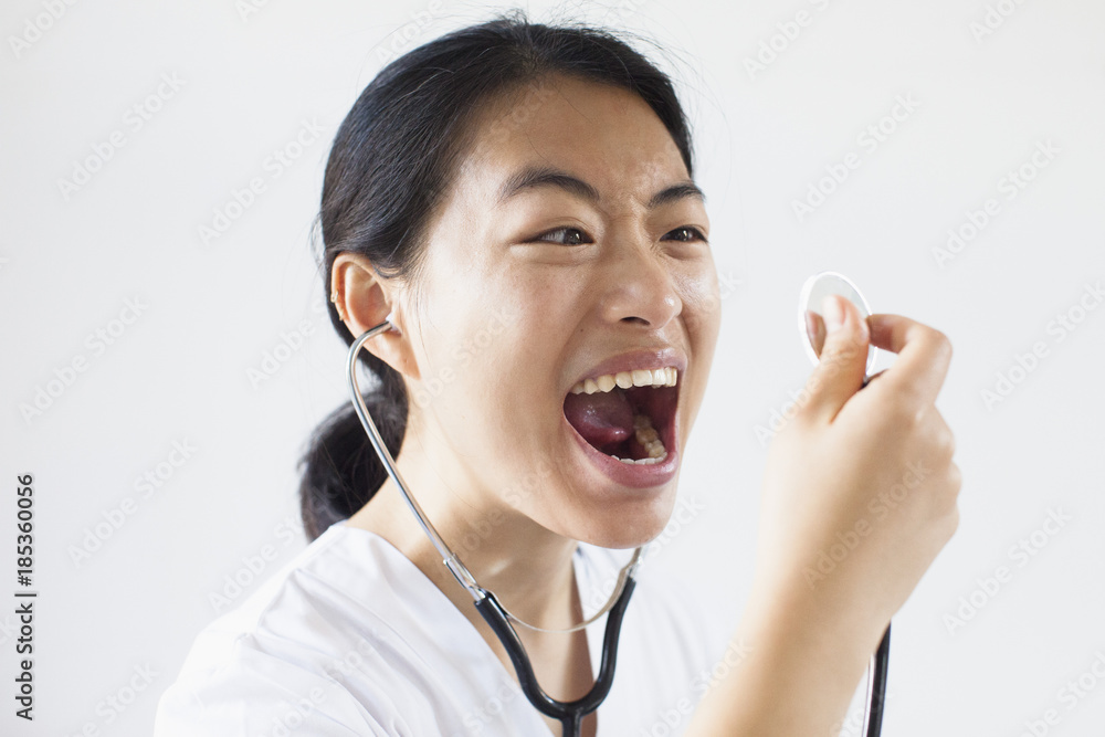 Foto de Frustrated doctor screaming with mouth open into stethoscope ...