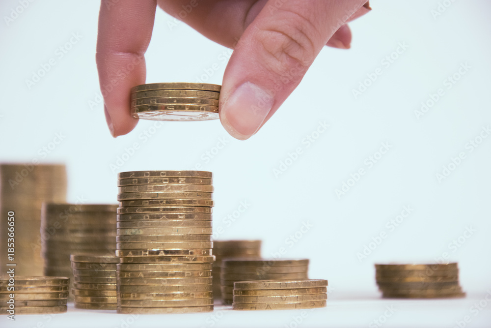 The hands of a woman's hand put gold coins. Columns of gold coins of ...