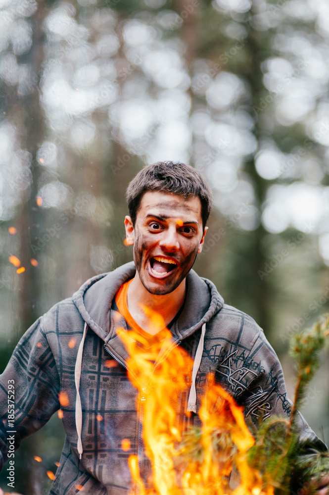 Foto de Happy funny crazy fearless man holding burning firewood in ...