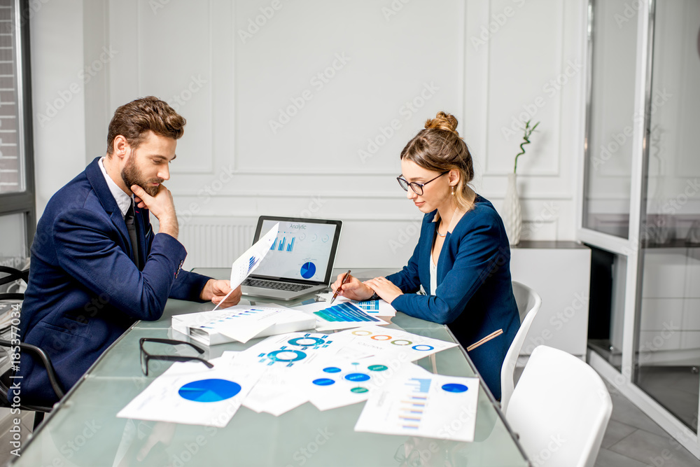 Marketer or analityc manager team dressed in suits working with paper ...