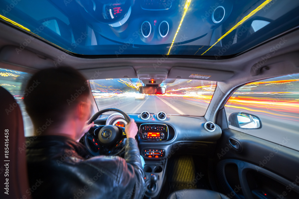 Urban high spees driving on a smal city car with panoramic roof. View ...