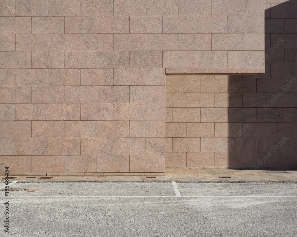 Urban background. Concrete road in front of a pink stone buildings made ...