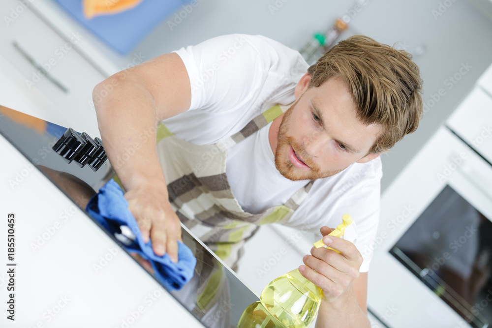 male janitor cleaning kitchen counter with detergent spray Stock Photo ...