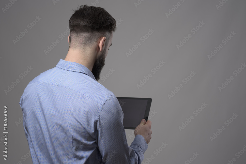 Over the shoulder view of young business man holding and reading blank ...