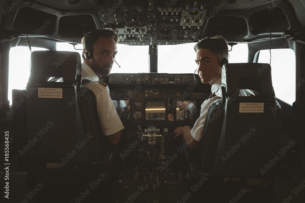 Pilot and copilot flying an airplane Stock Photo | Adobe Stock