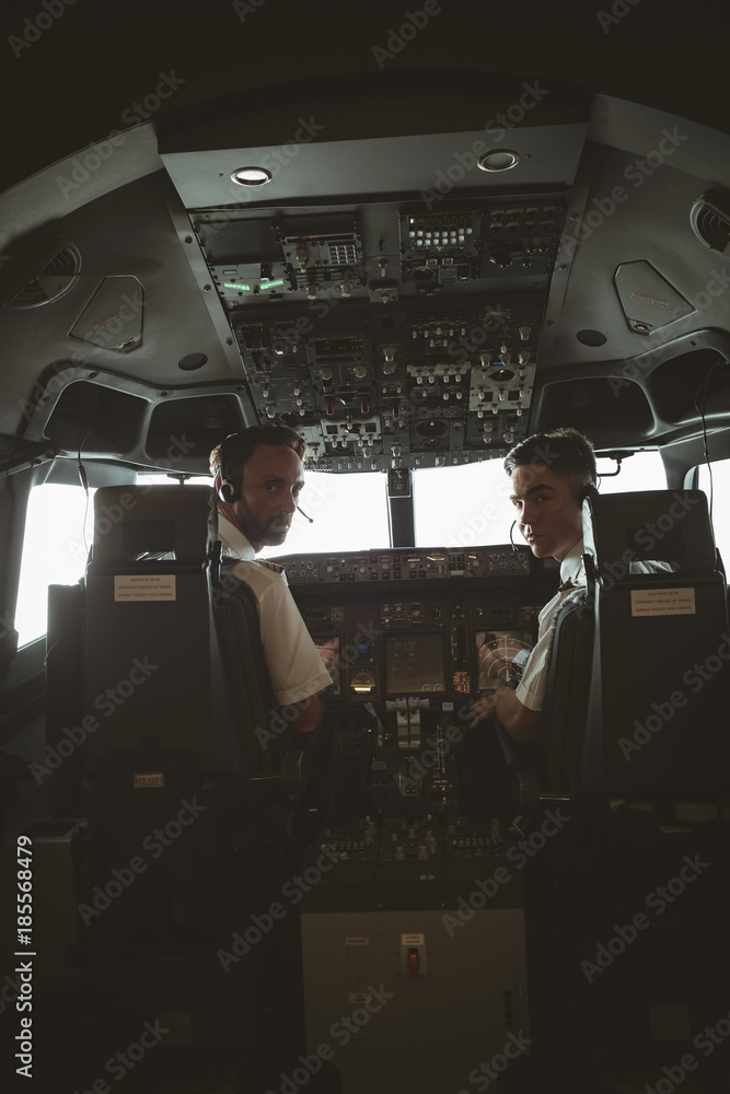 Pilot and copilot flying an airplane Stock Photo | Adobe Stock
