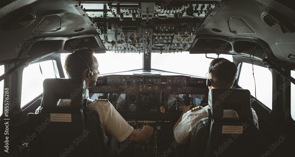 Pilot and copilot flying an airplane Stock Photo | Adobe Stock