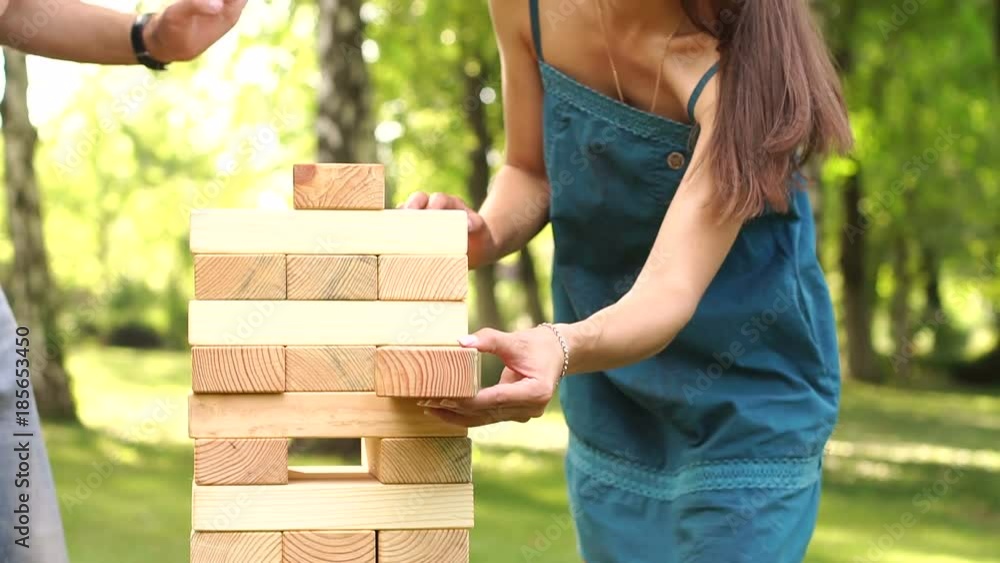 People playing Jenga game. Two young friends, guy and girl are playing ...