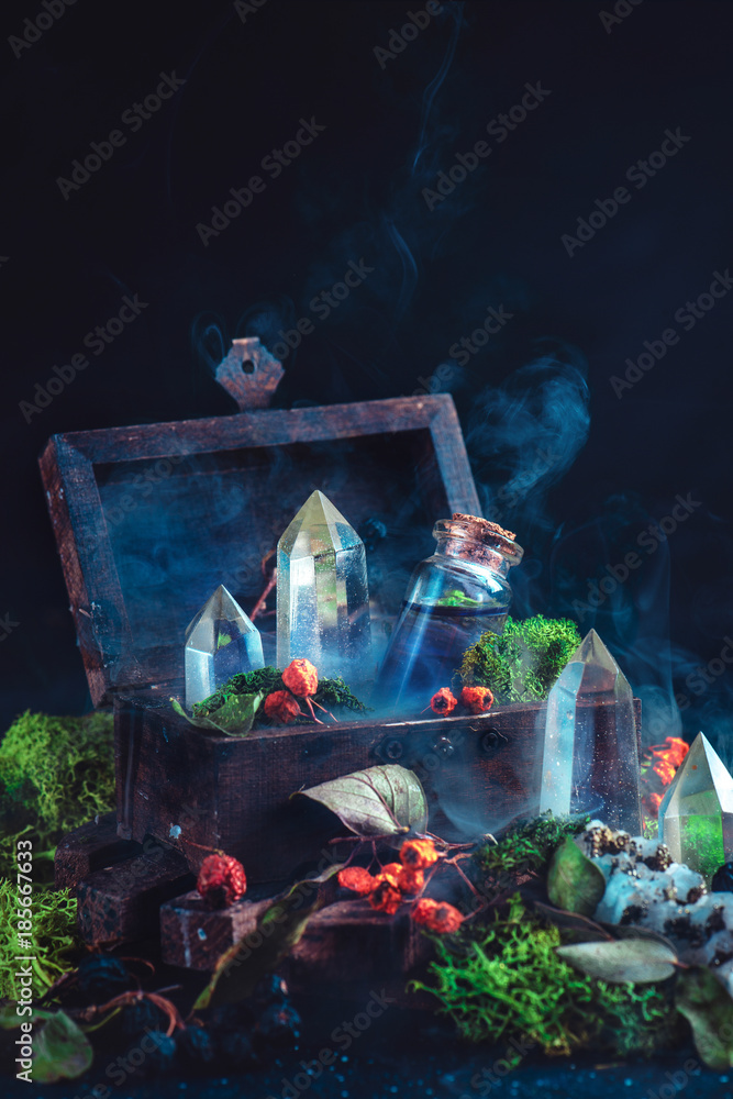 Magical still life with a wooden chest, potion bottle, crystals, moss ...