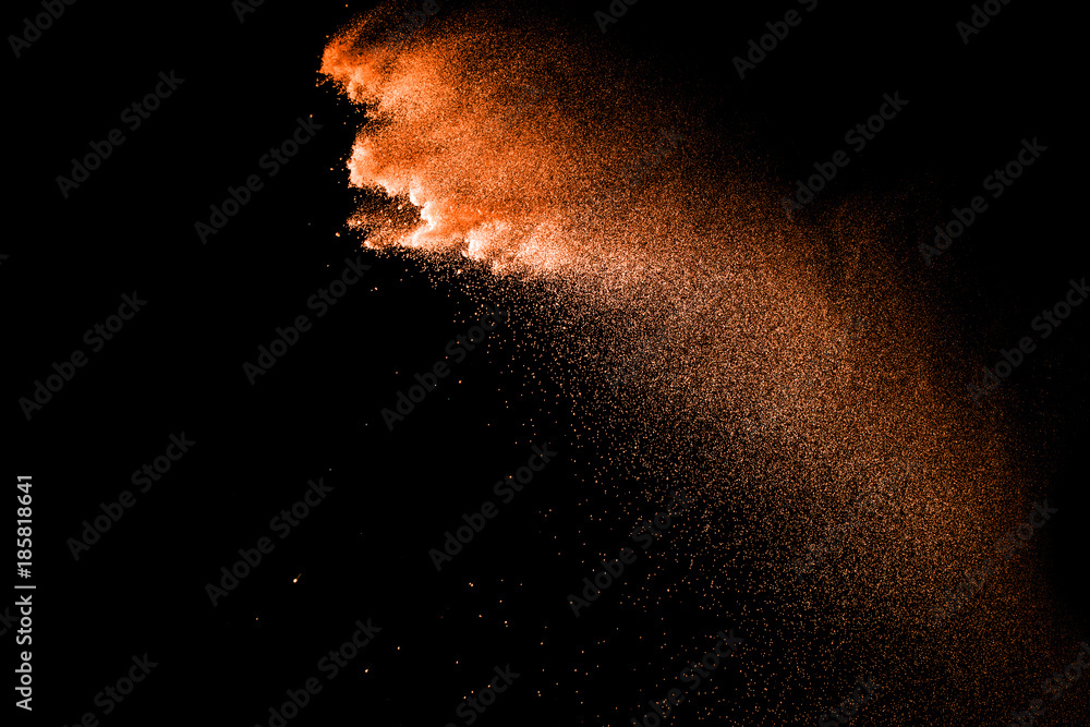 Orange particles explosion on black background. Freeze motion of orange ...