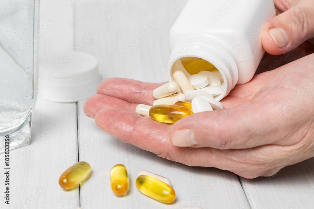 Woman hands hold vitamin complex and dietary supplement, pours from ...