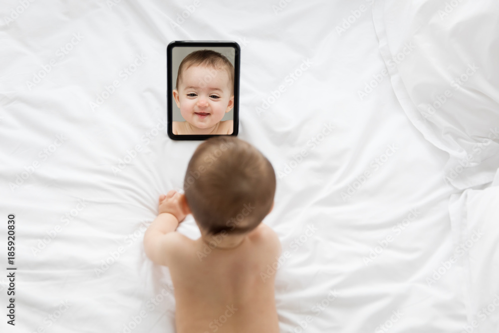 Baby smiling at her reflection in the mirror Stock Photo | Adobe Stock