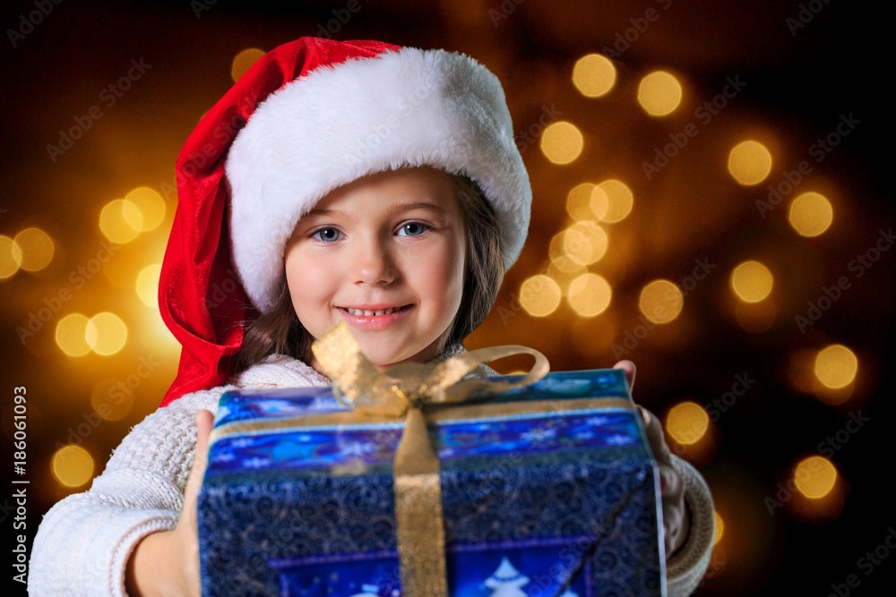 Child giving a christmas present. Stock Photo | Adobe Stock