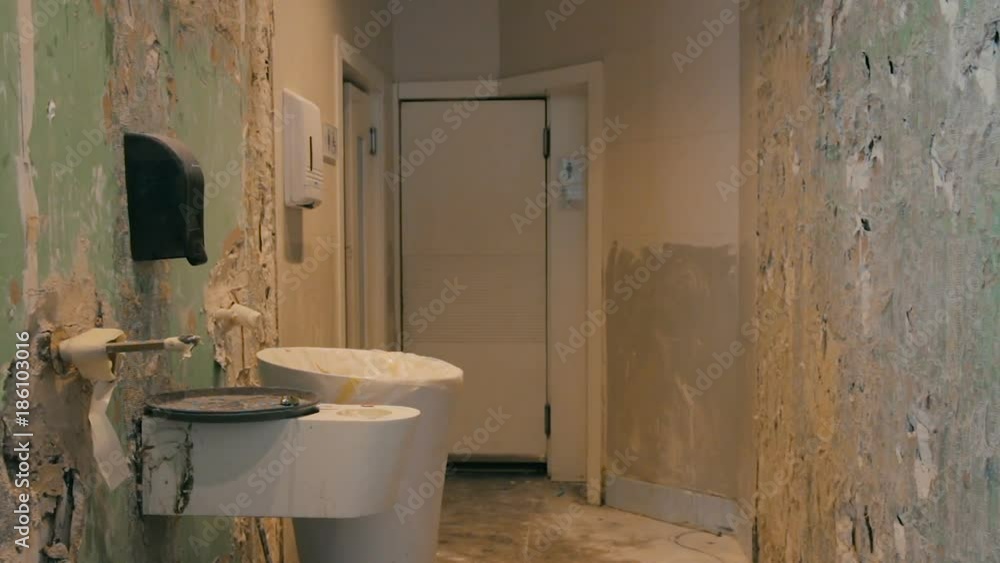Public restroom renovation in messy stage with tiles removed from the ...