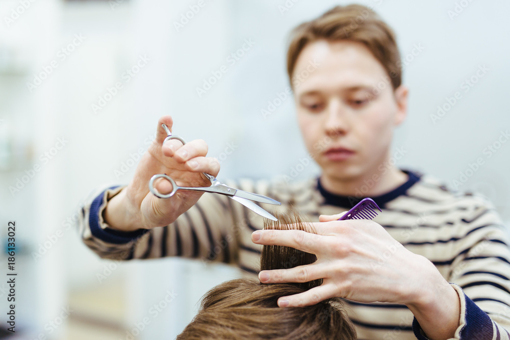 hairdresser in the beauty salon does a haircut Stock Photo | Adobe Stock