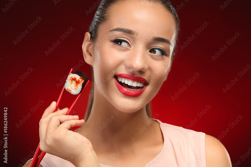 Beautiful young woman with sushi roll on color background Stock Photo ...