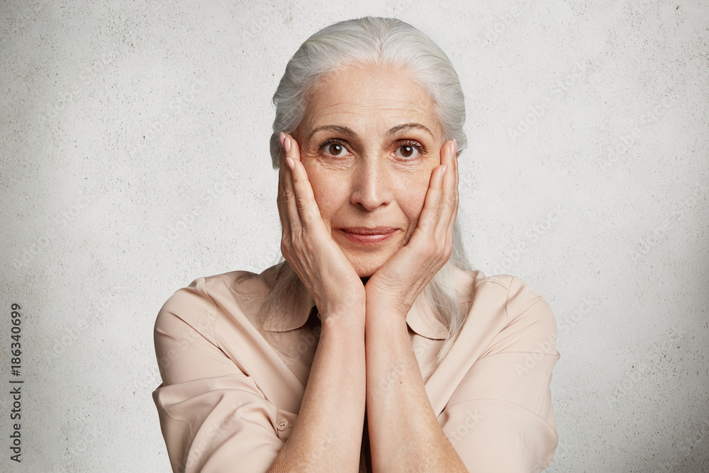 Headshot of elderly beautiful woman with grey hair, make up, keeps ...