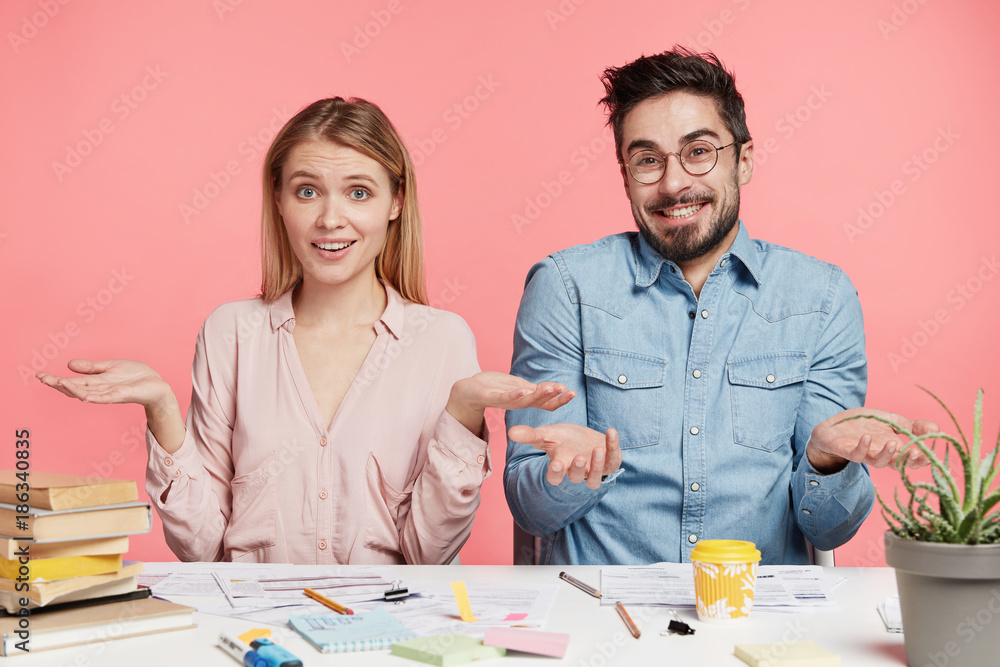 Positive hesitant female and male students shrug shoulders, don`t know ...
