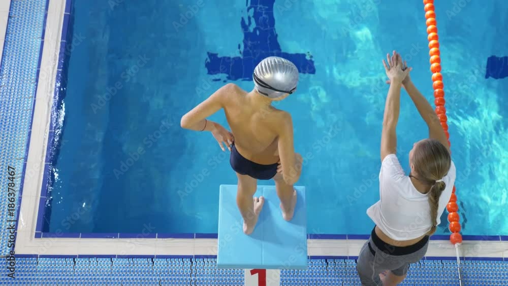 swim athlete training. The coach teaches the boy to dive into the ...