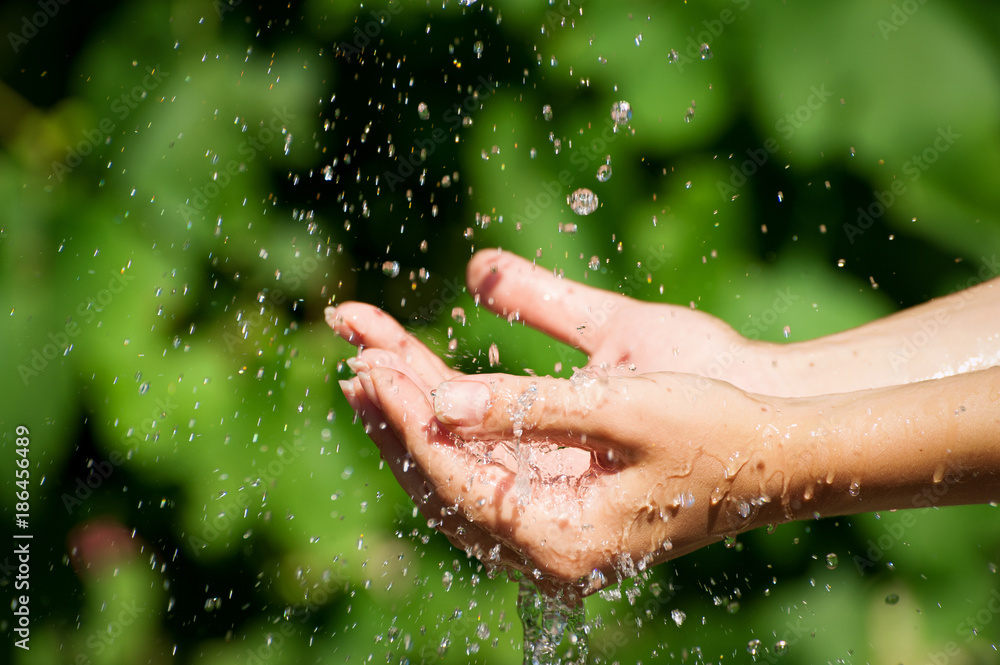 Woman washing hand outdoors. Natural drinking water in the palm. Young ...